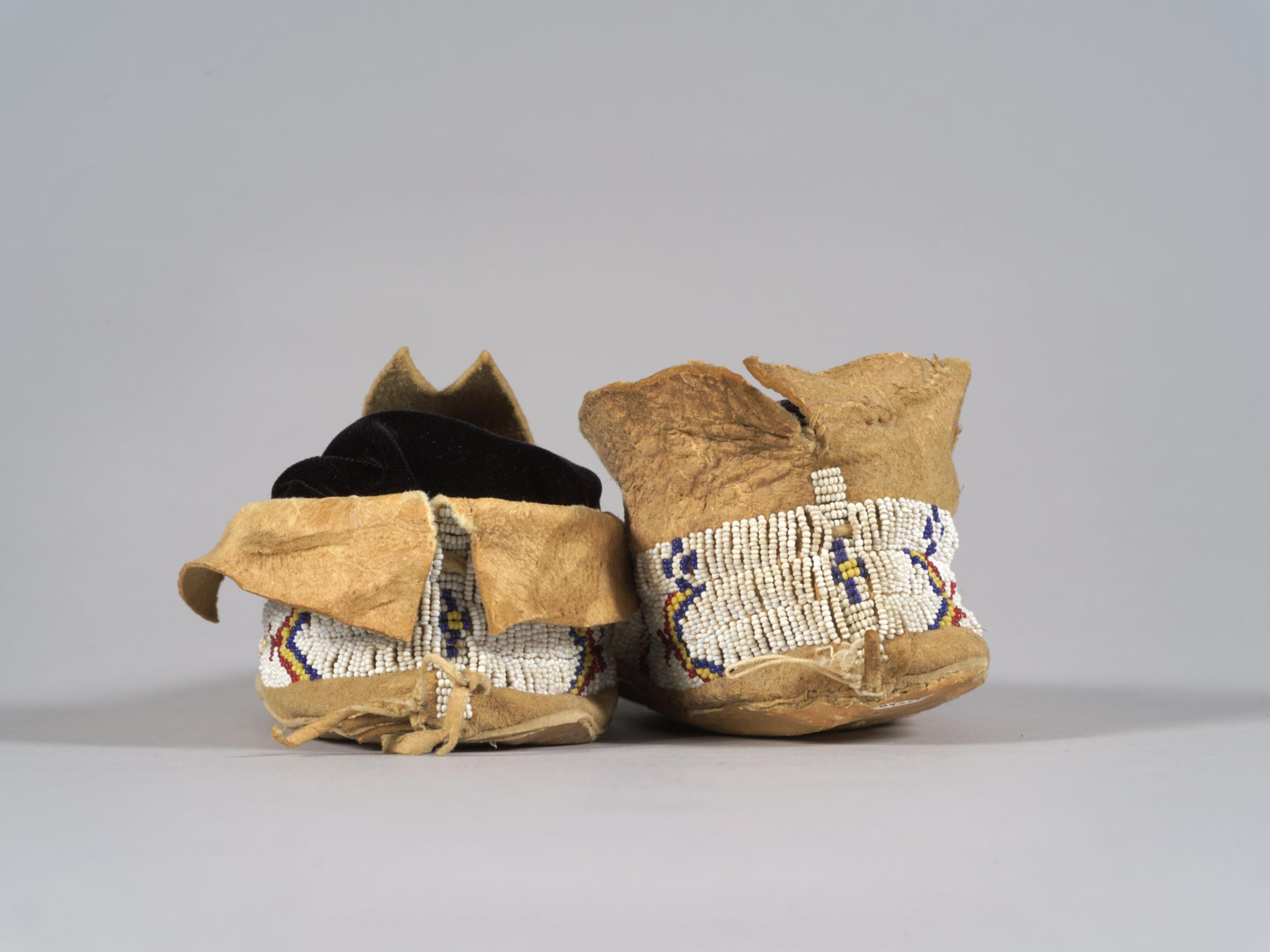 Woman’s beaded leather moccasins with white beaded field and various ...